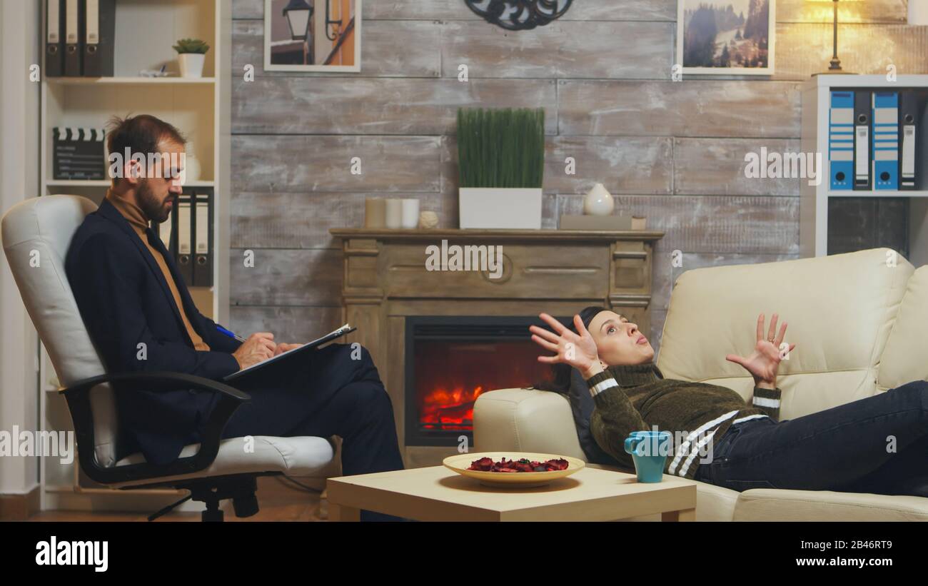 Young man laying on couch at couple therapy talking with psychologist ...