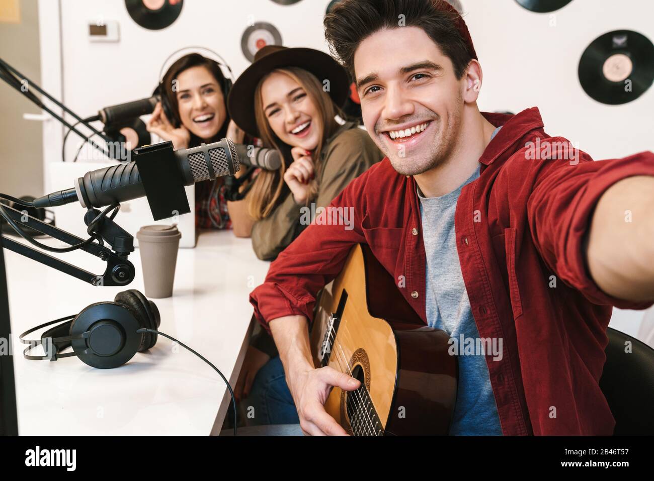 Image of young happy caucasian people performing at radio program while ...