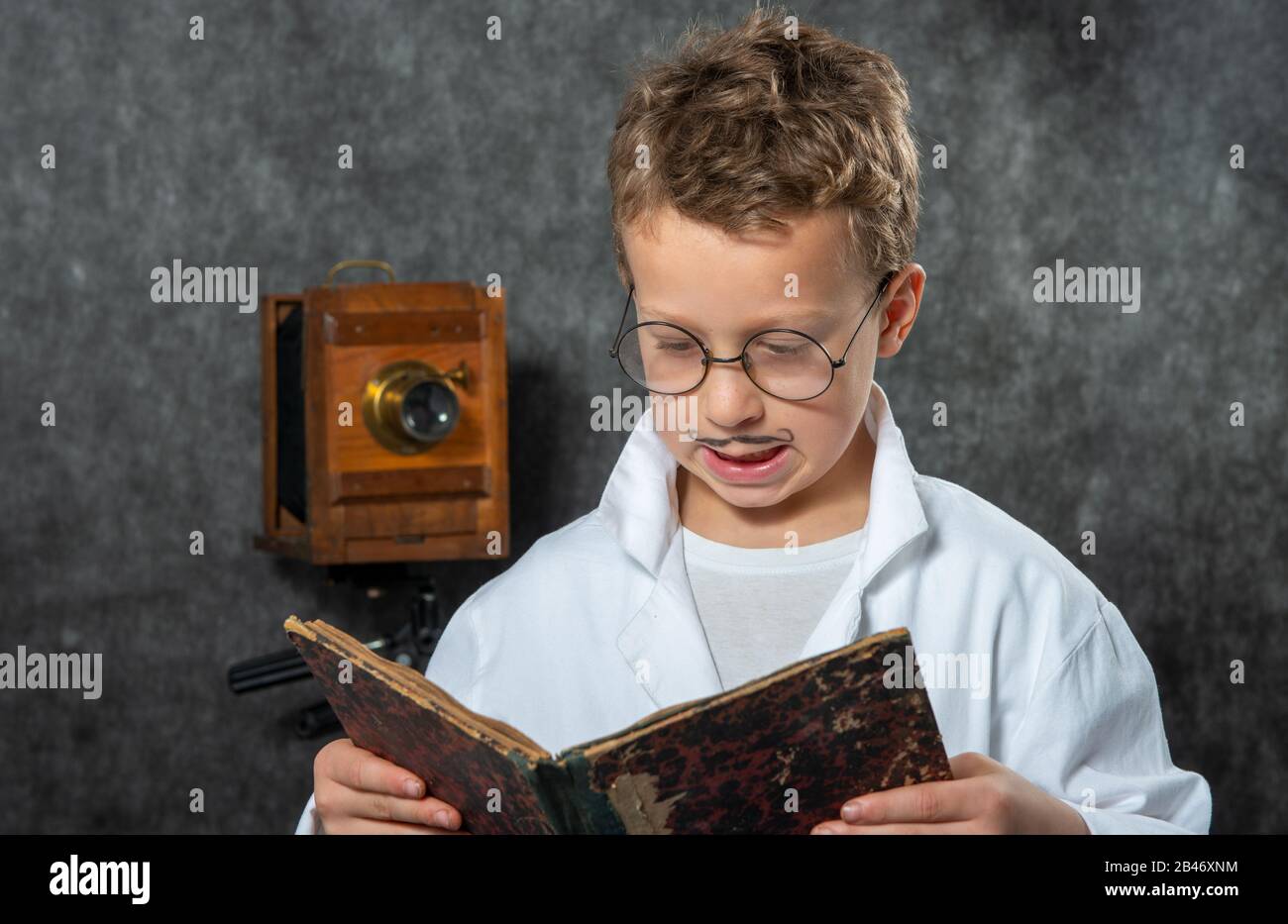 cheerful boy retro with a white blouse reading a book Stock Photo - Alamy