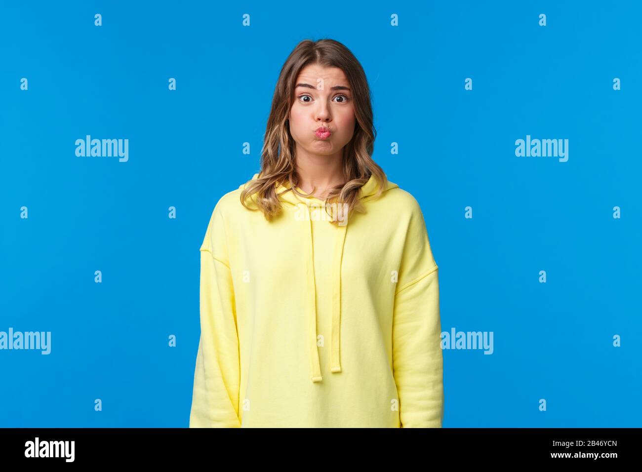 Silly and cute blond female pouting, hold her breath as promise being ...