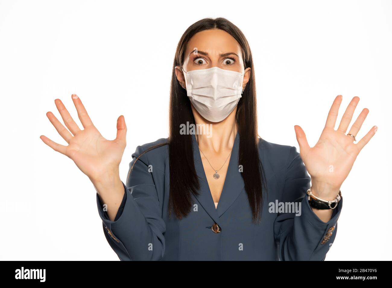 Shocked woman with stop hands and protective mask on her face on white ...