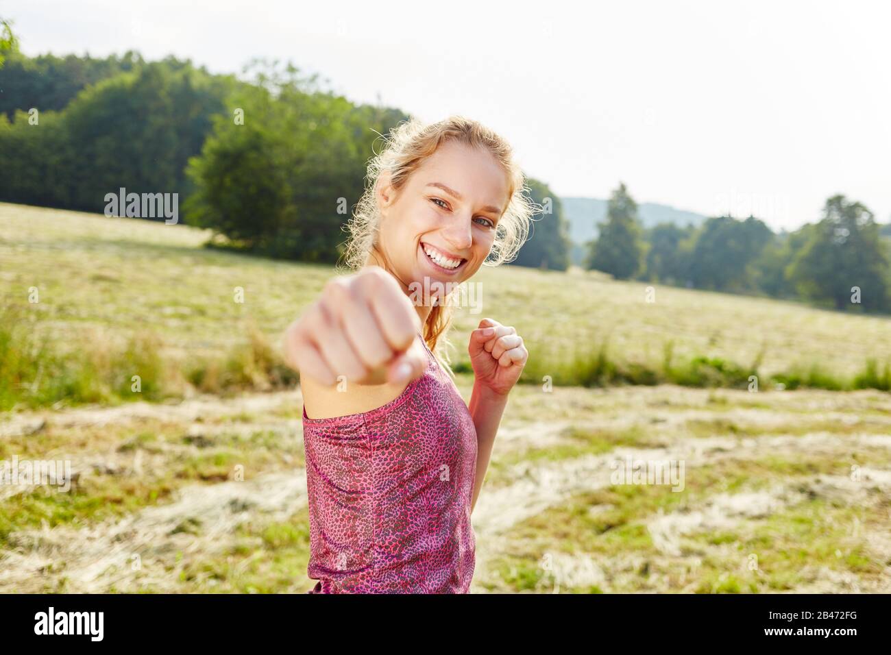 Young woman makes fist while boxing as a workout in nature Stock Photo ...
