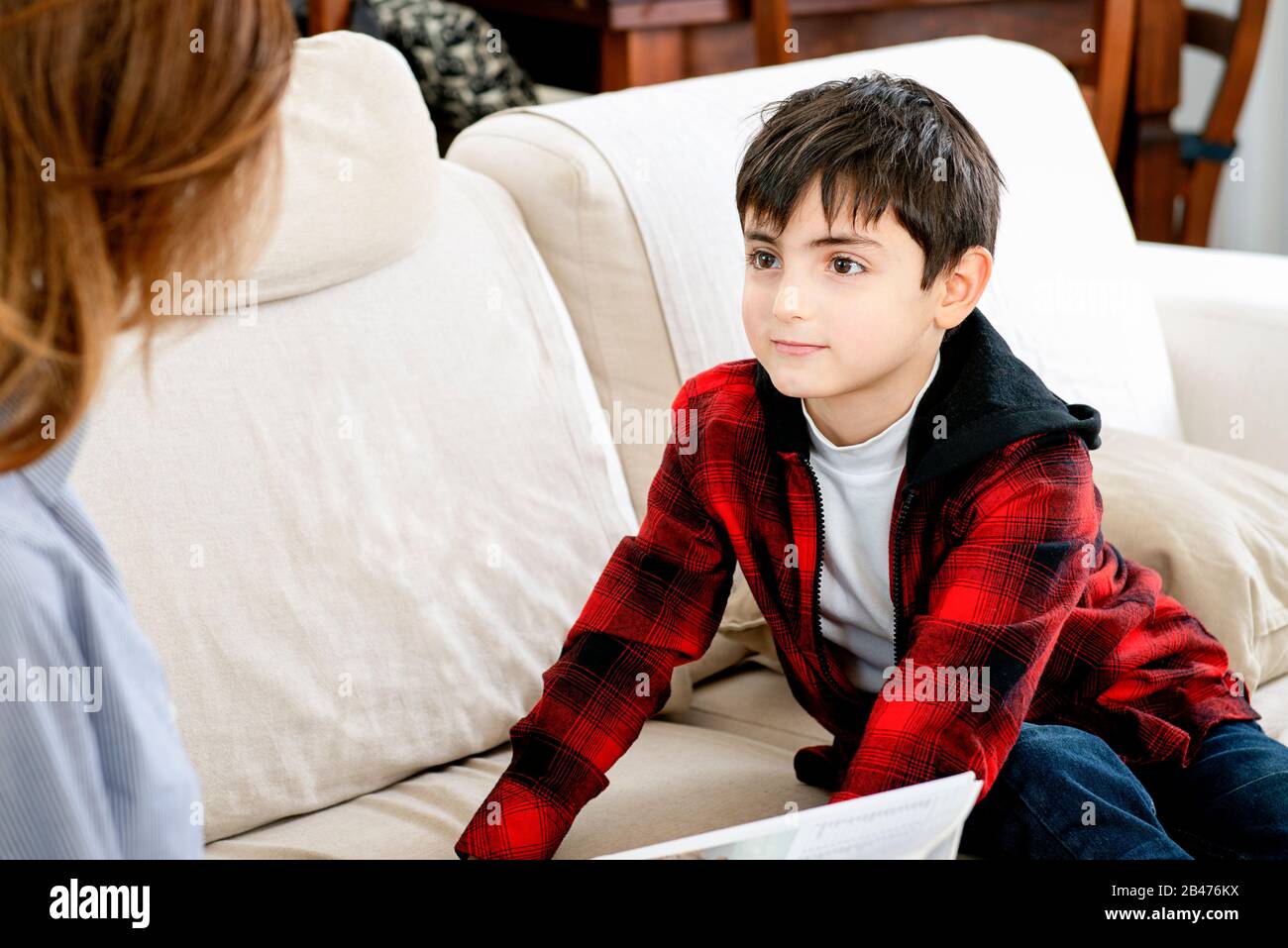 engaged child listens to the mother who tells him a story in home ...