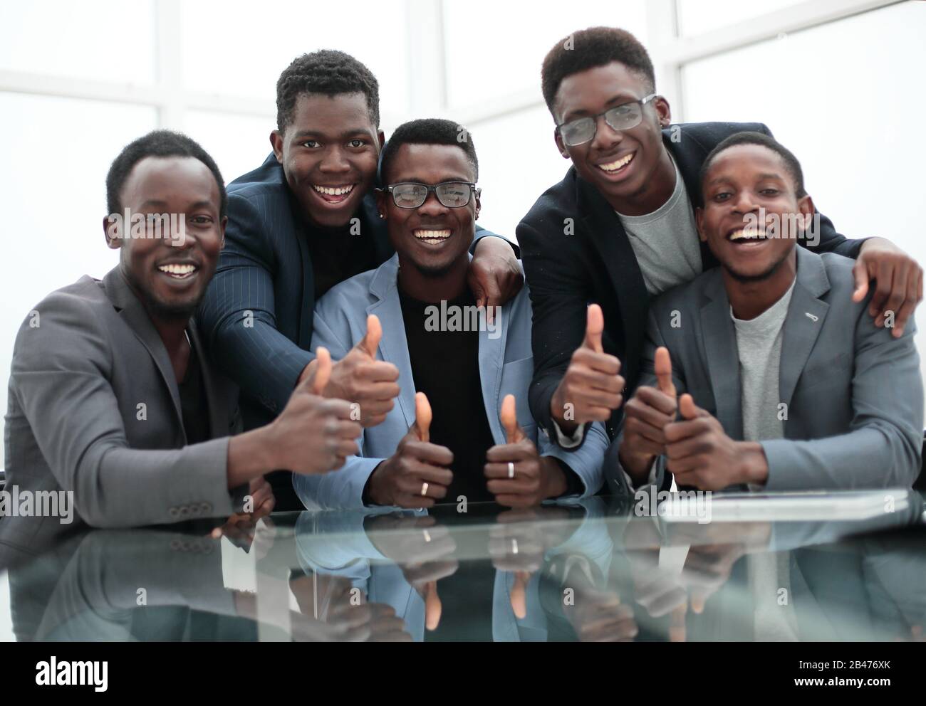 group of smiling employees giving a thumbs up Stock Photo - Alamy