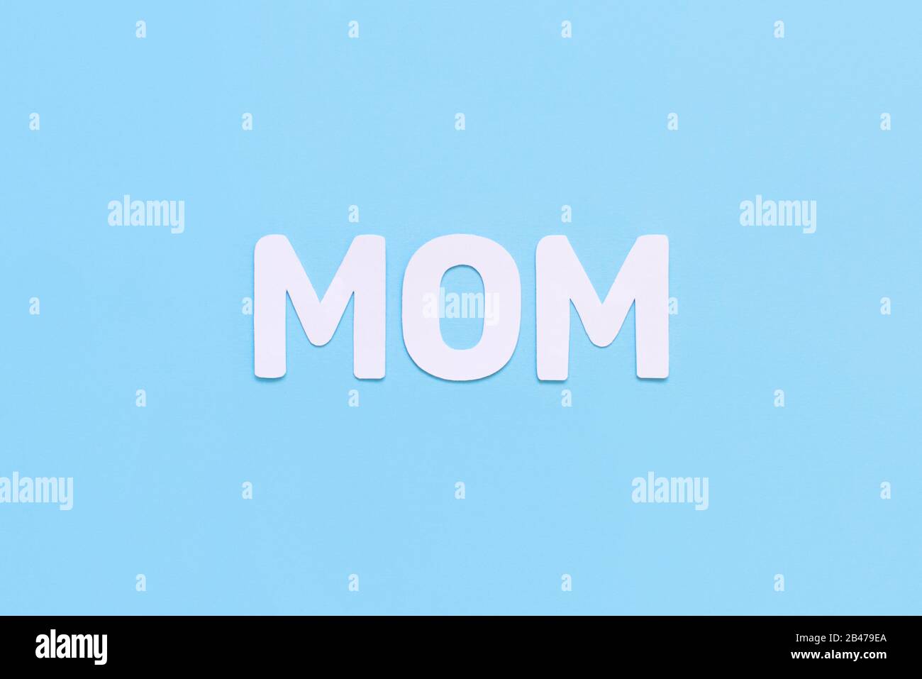 Letters MOM on a light blue background top view Stock Photo - Alamy