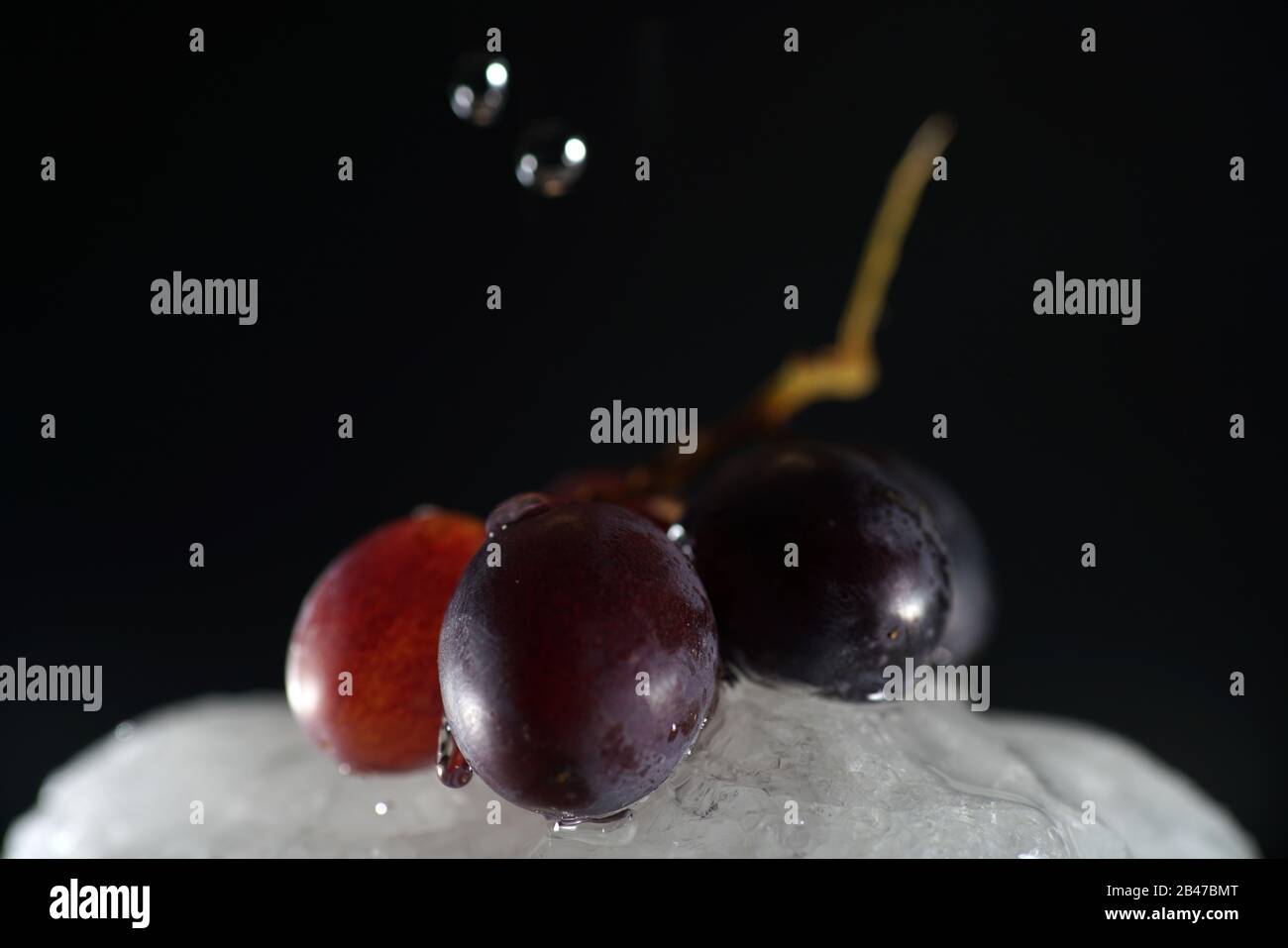 Bunches of grapes in ice water with colorful flashes photographed in ...