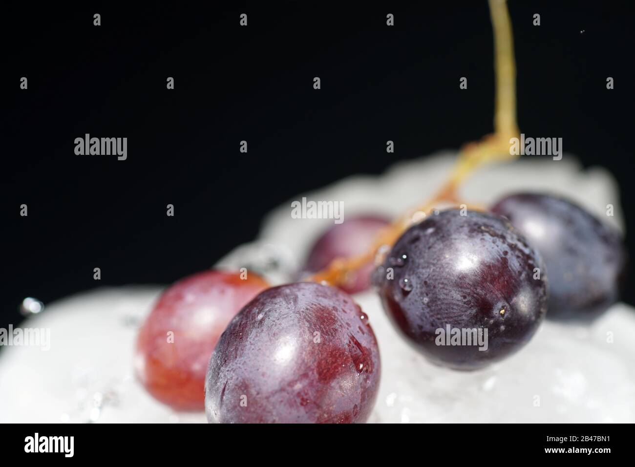 Bunches of grapes in ice water with colorful flashes photographed in ...