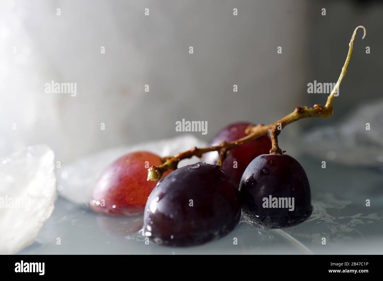 Bunches of grapes in ice water with colorful flashes photographed in ...