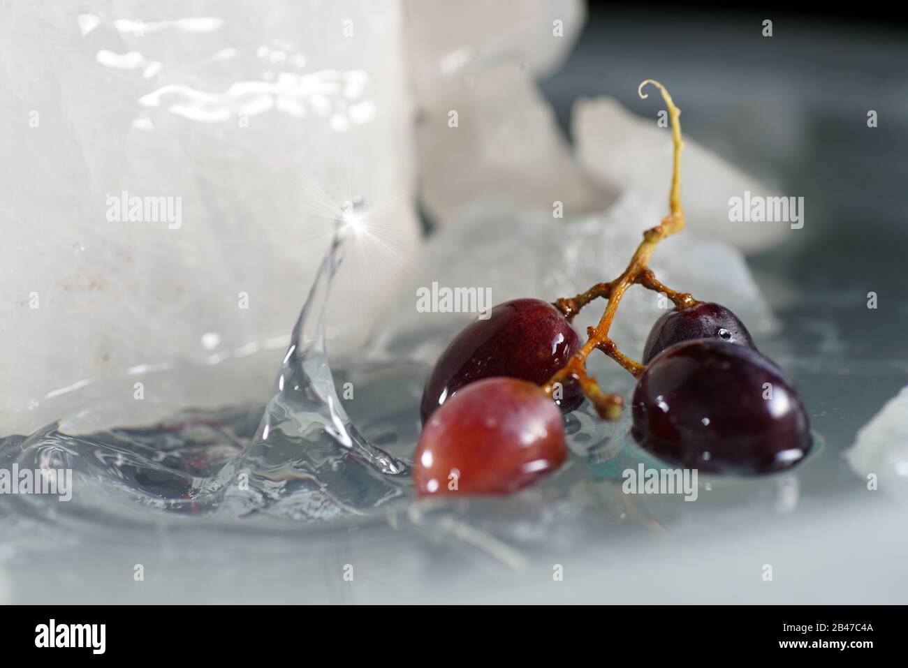 Bunches of grapes in ice water with colorful flashes photographed in ...