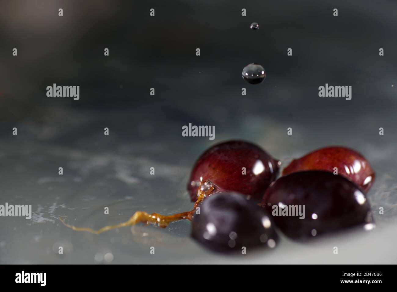 Bunches of grapes in ice water with colorful flashes photographed in ...