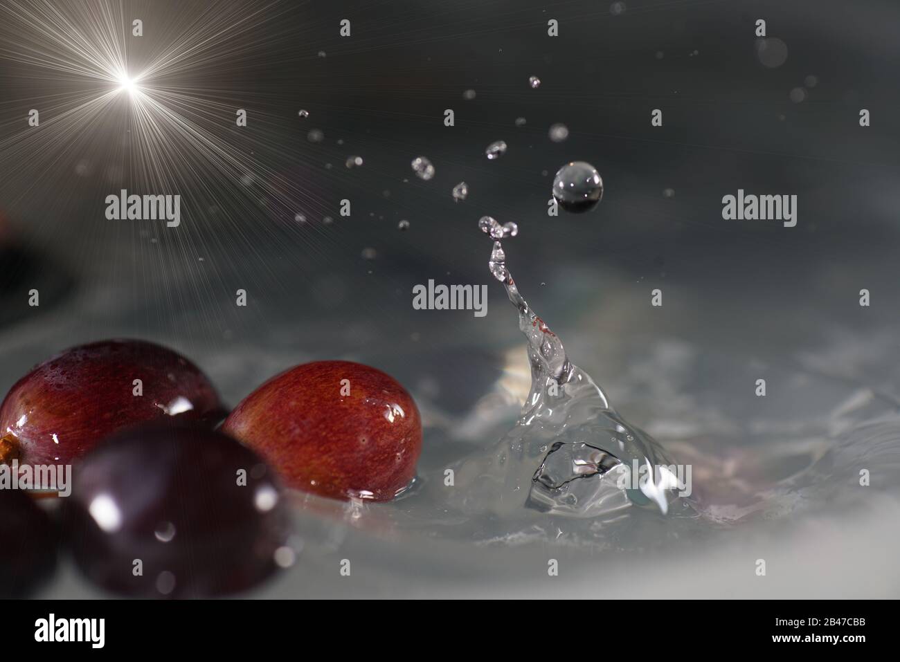 Bunches of grapes in ice water with colorful flashes photographed in ...