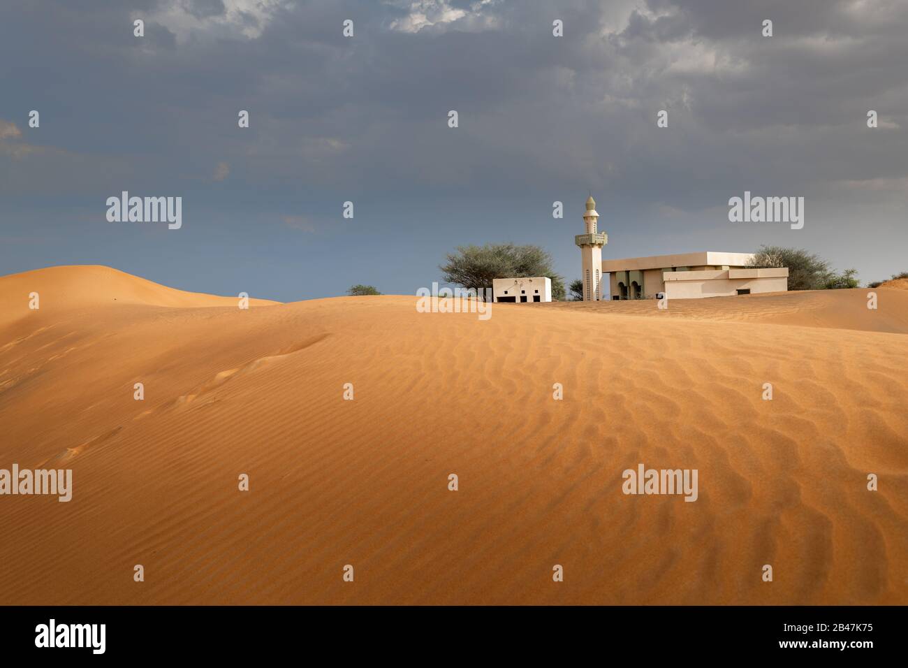 abandoned mosque in the desert, surrounded by sand dunes, as nature is ...