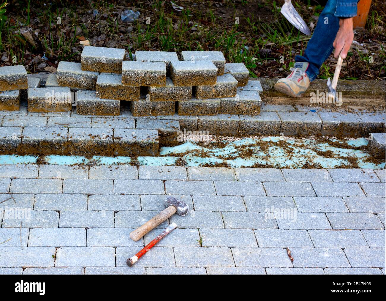 Maintenance work on paving with interlocking paving stones. Building ...