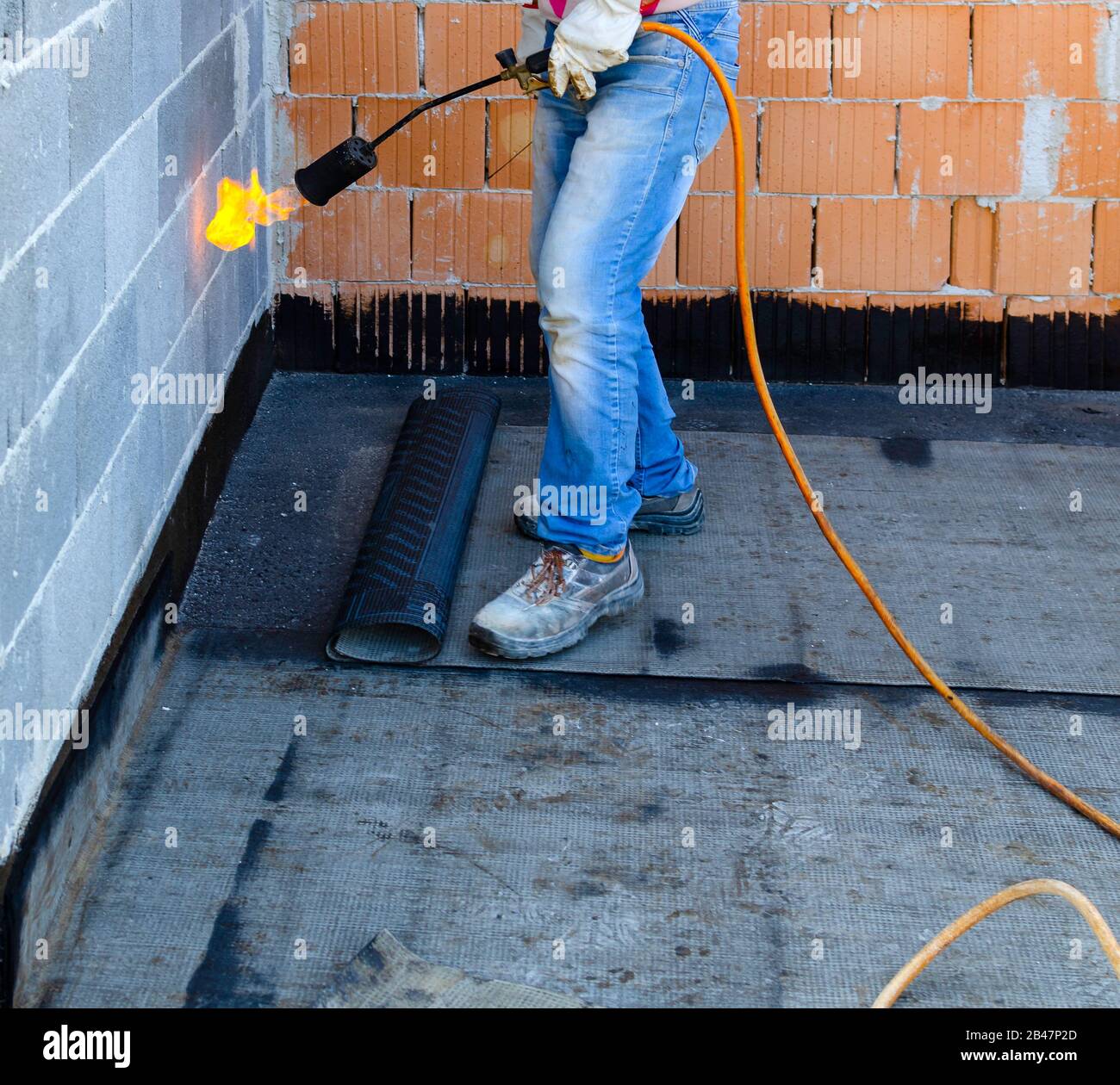Flat roof installation. Heating and melting bitumen roofing felt Stock Photo - Alamy