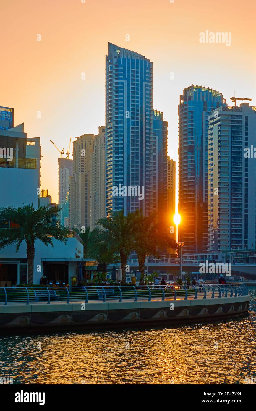 The Sun between buildings of Dubai Marina at sunset, United Arab ...