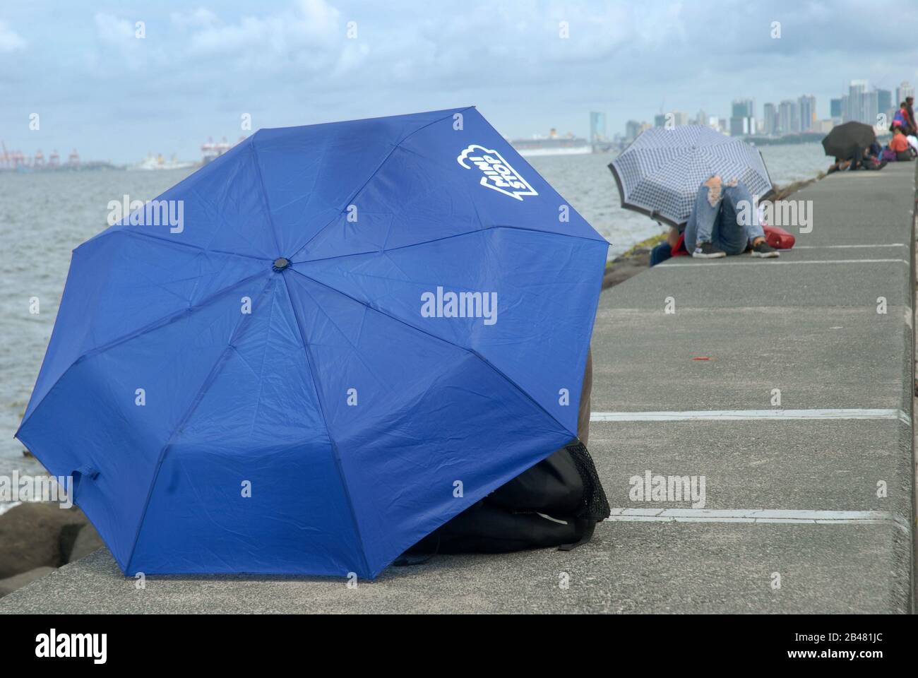 Young couple manila hugging under an umbrella, Promenade, Manila Bay ...