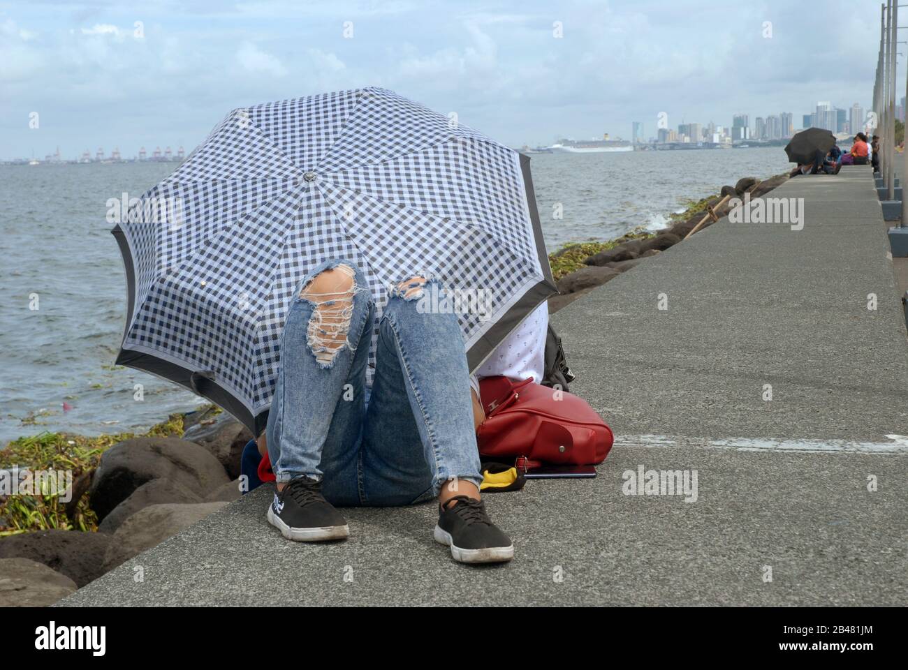 Young couple manila hugging under an umbrella, Promenade, Manila Bay ...