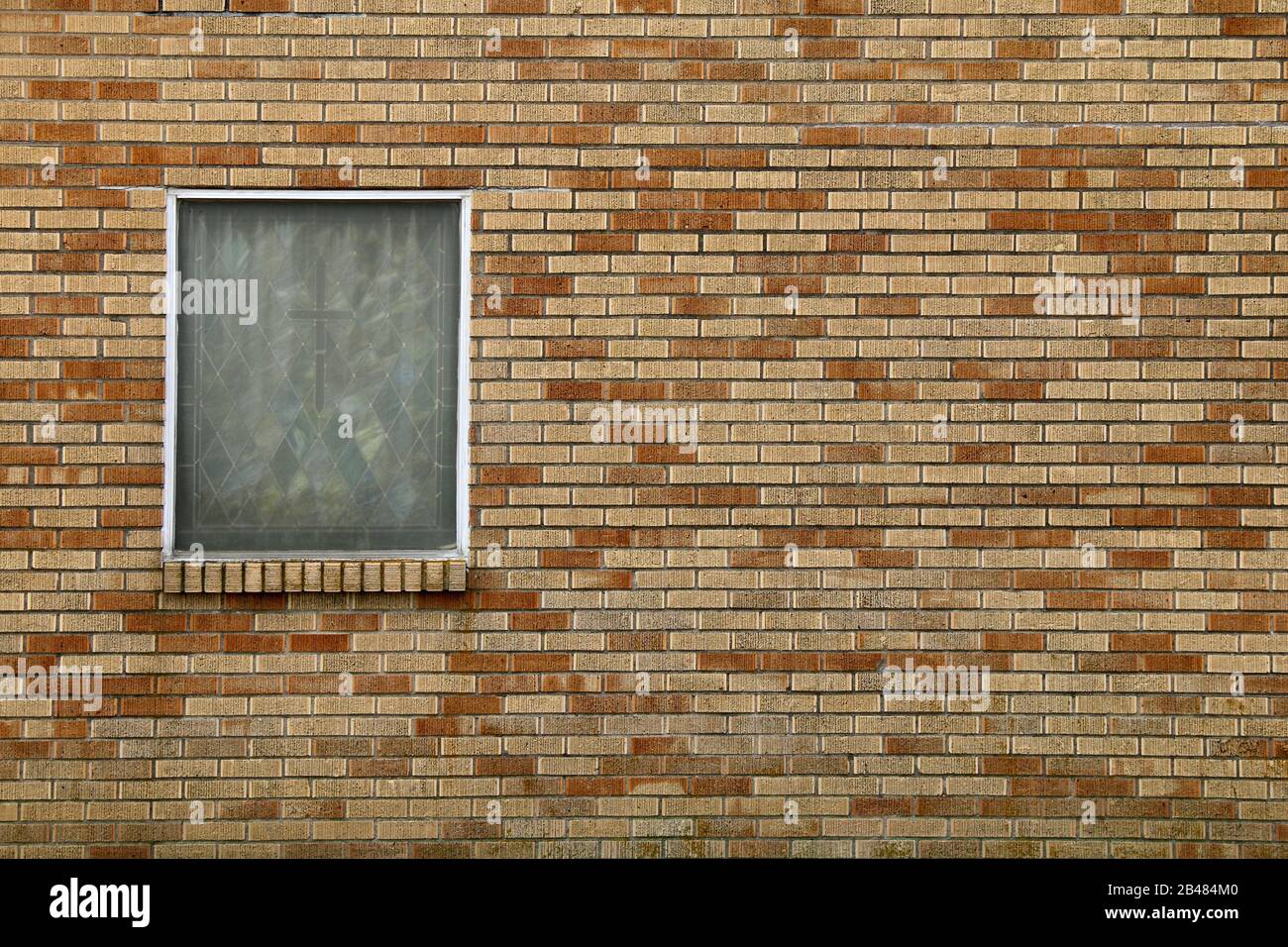 a single stained glass window on a colorful brick church wall Stock ...