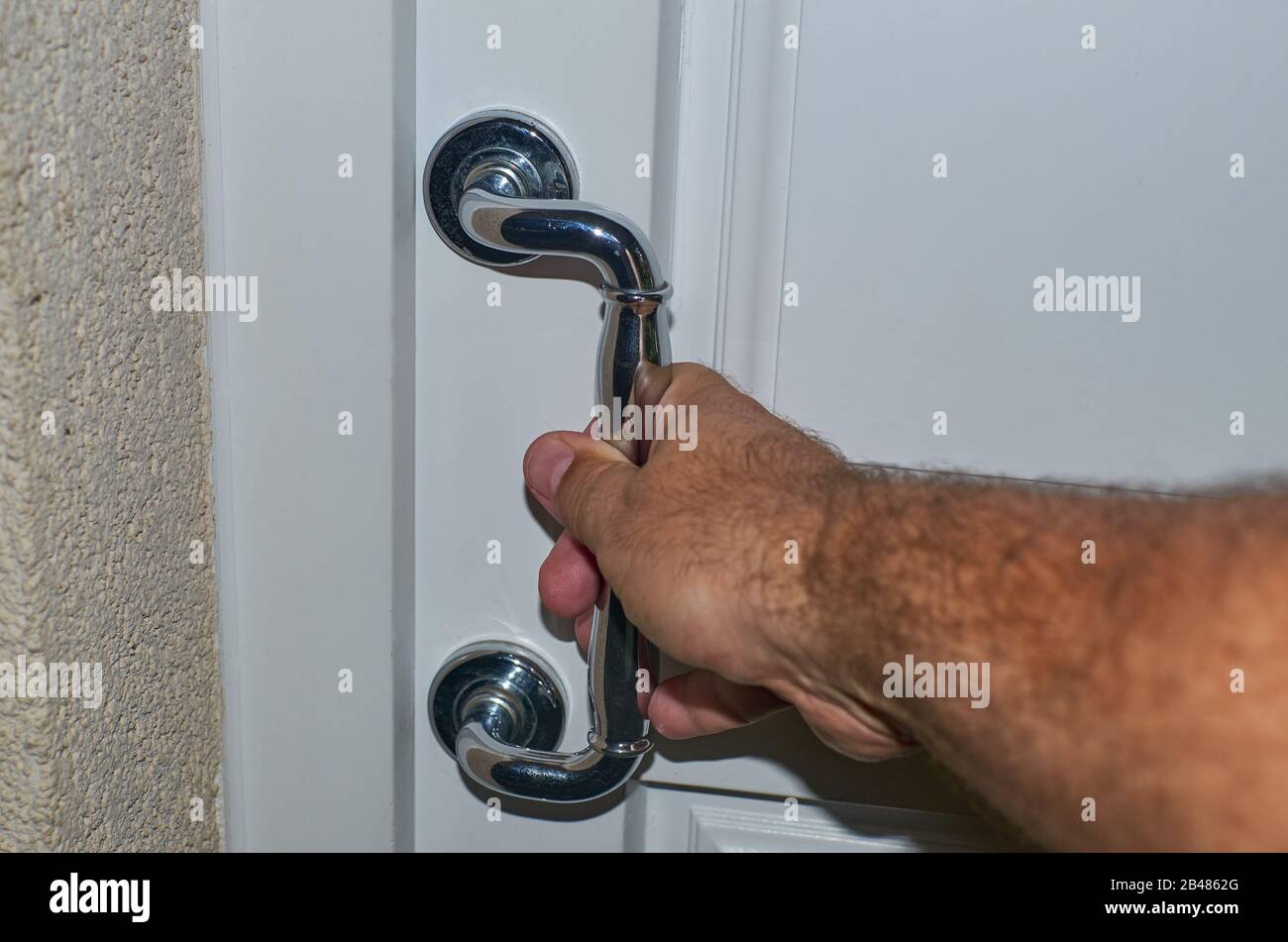 Close-up of a man's hand holding a door handle - first person point of ...