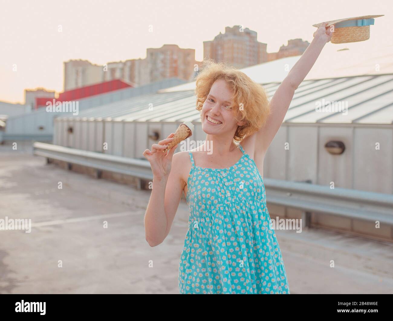 young happy cheerful curly redhead woman in straw hat, blue sundress ...