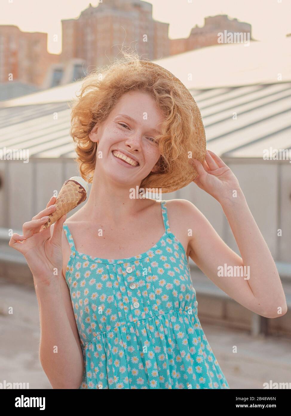 young happy cheerful curly redhead woman in straw hat, blue sundress ...