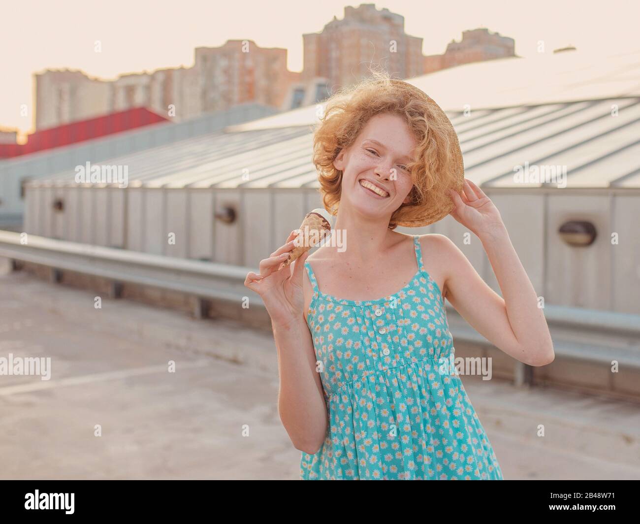young happy cheerful curly redhead woman in straw hat, blue sundress ...