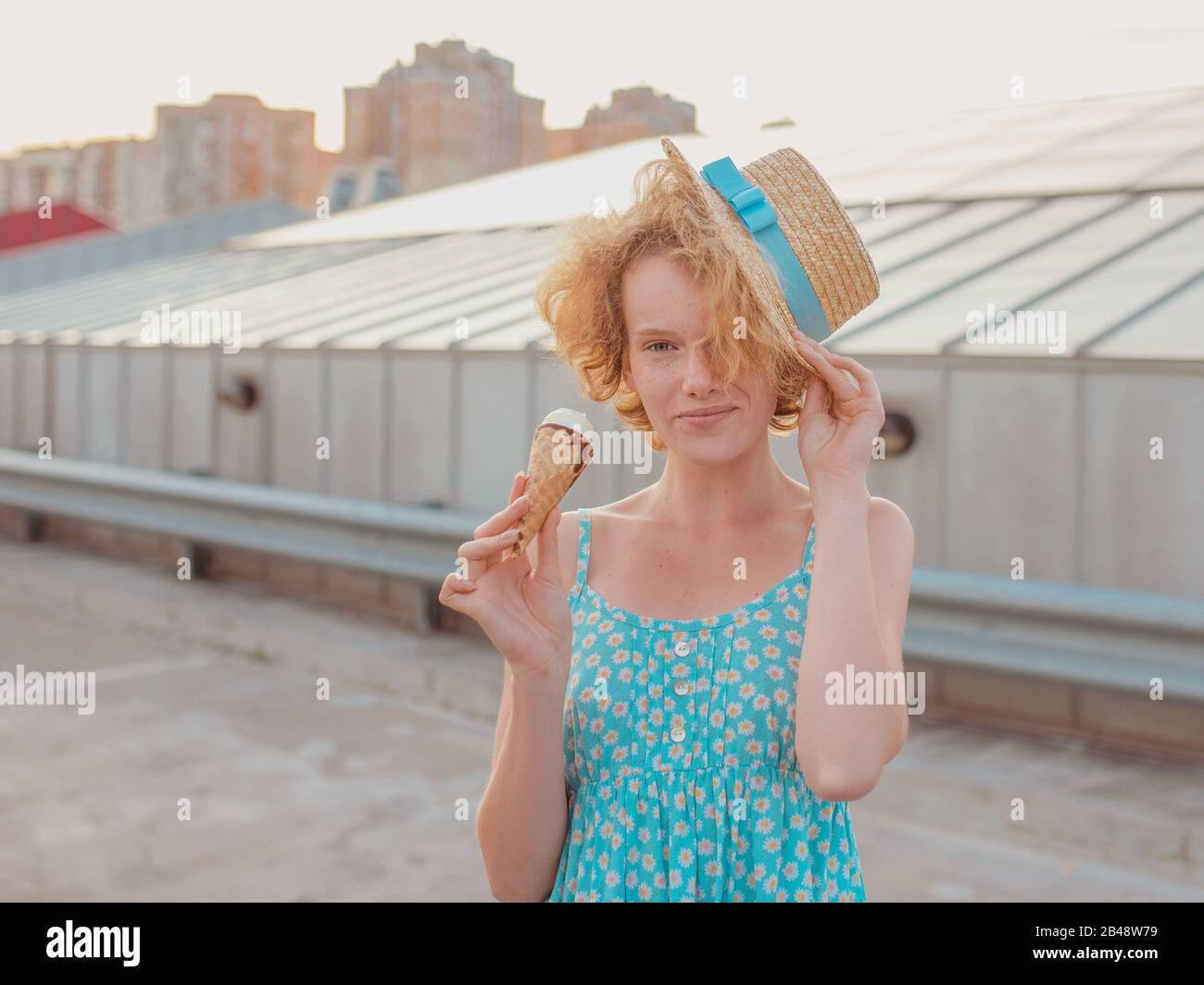 young happy cheerful curly redhead woman in straw hat, blue sundress ...
