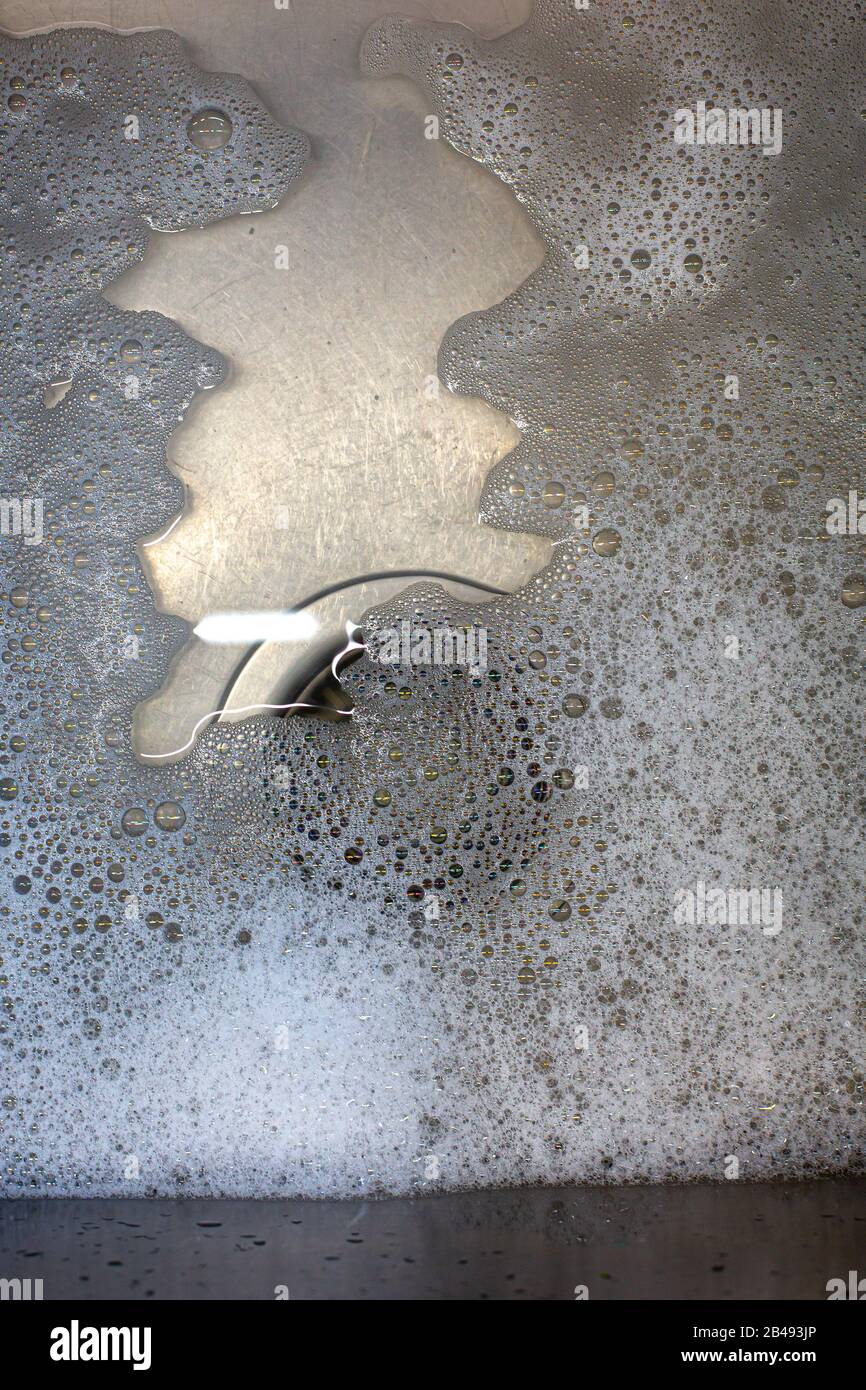 foam on washing-up water in a stainless steel sink (copy space Stock ...