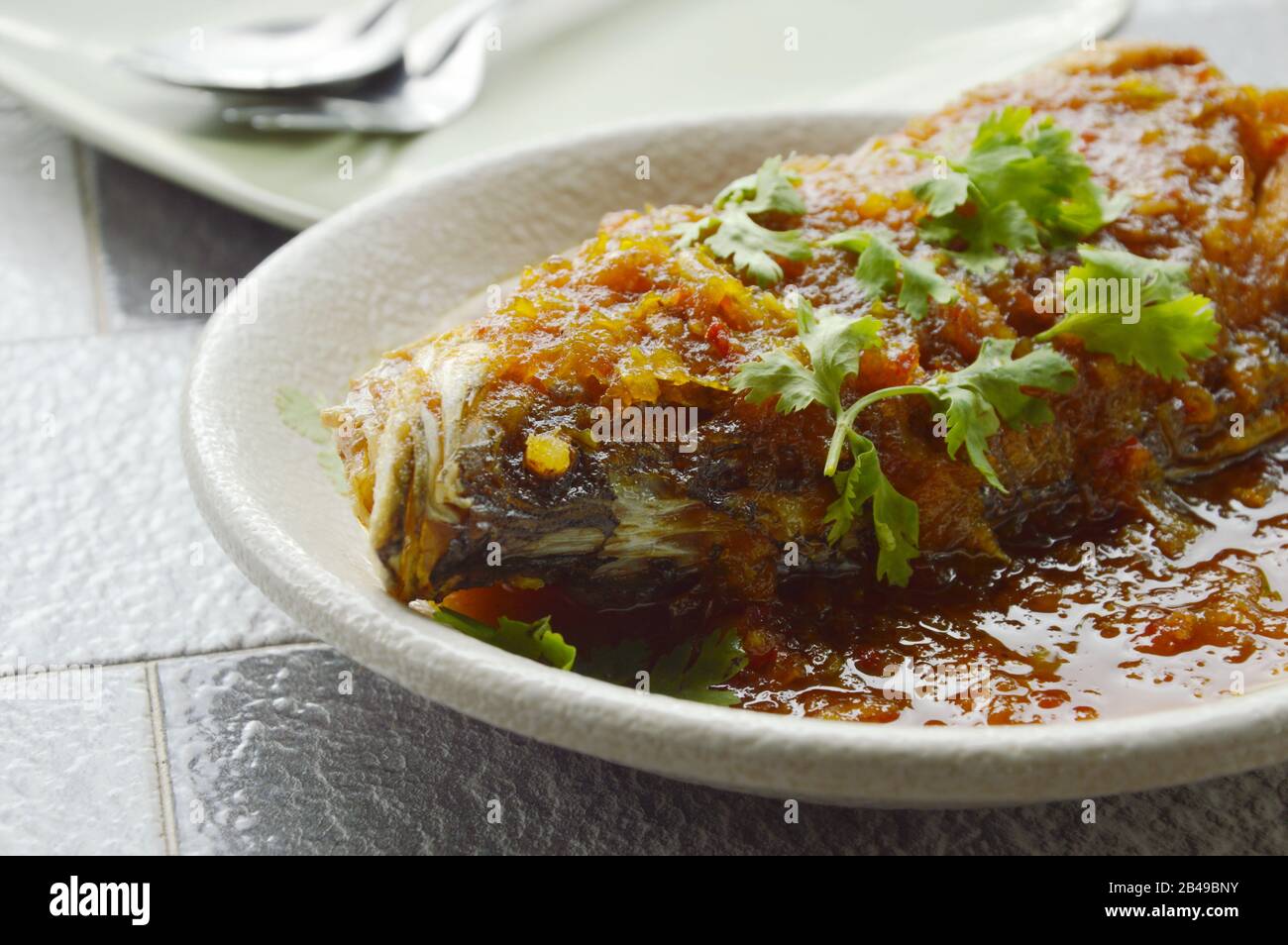 fried bass fish dressing with sweet chili sauce on plate Stock Photo ...