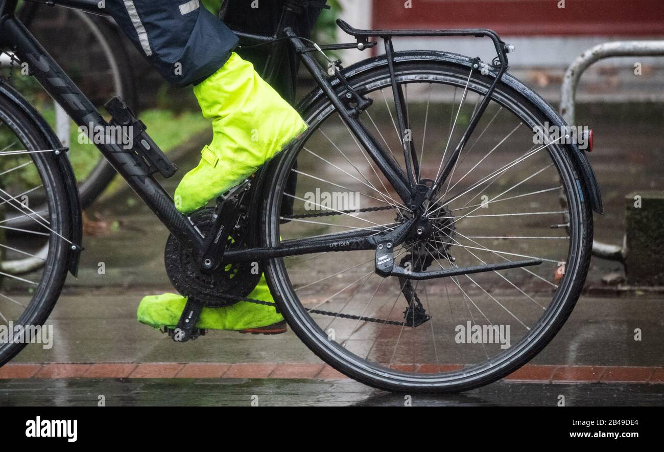 Hanover, Germany. 06th Mar, 2020. A cyclist with overcoats over his ...