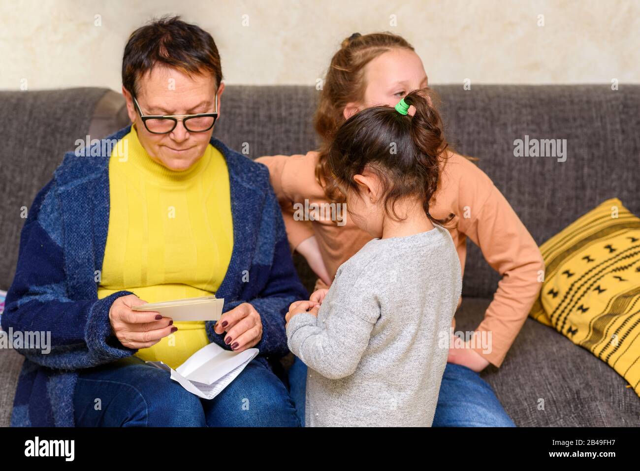Grandma Looking At Old Photos With Grandchildren To Refresh Memory ...