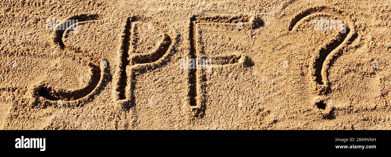 Sun protect factor concept. SPF word written on the beach with question ...