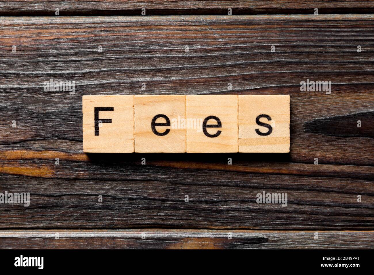 Fees word written on wood block. Fees text on wooden table for your ...