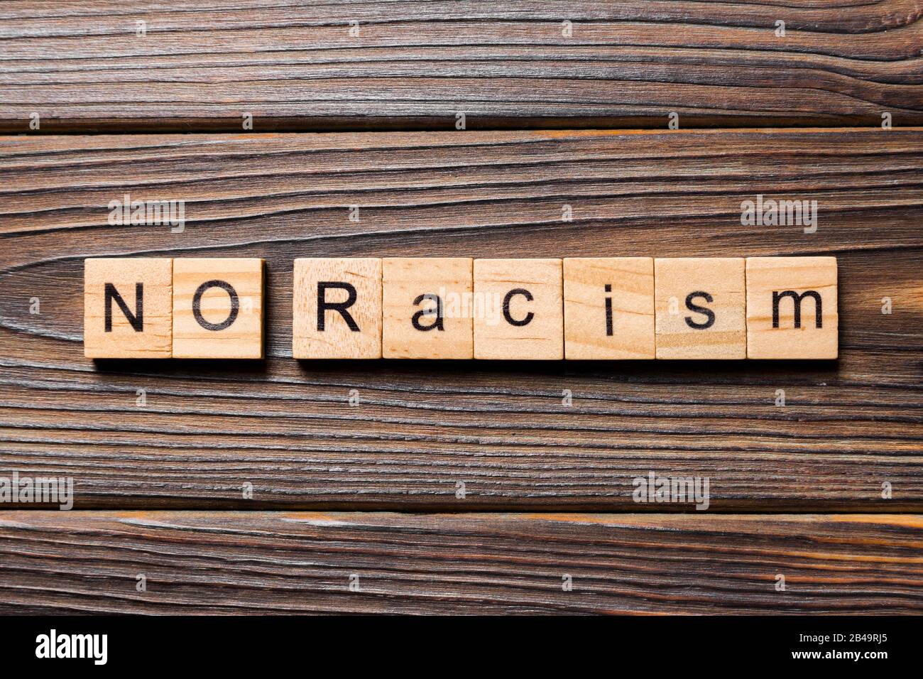 No racism word written on wood block. No racism text on table, concept ...