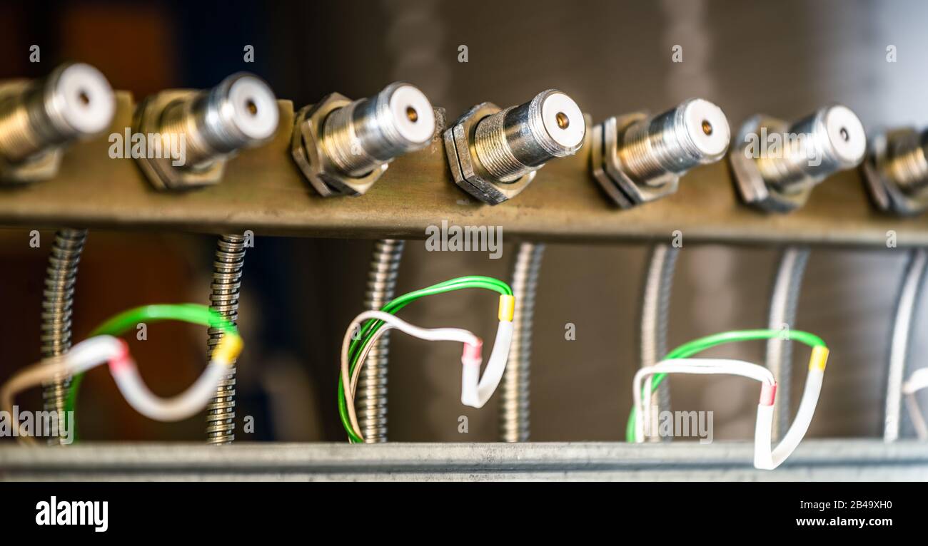 Rows of metal round plugs connected to each other by wires hang on a ...