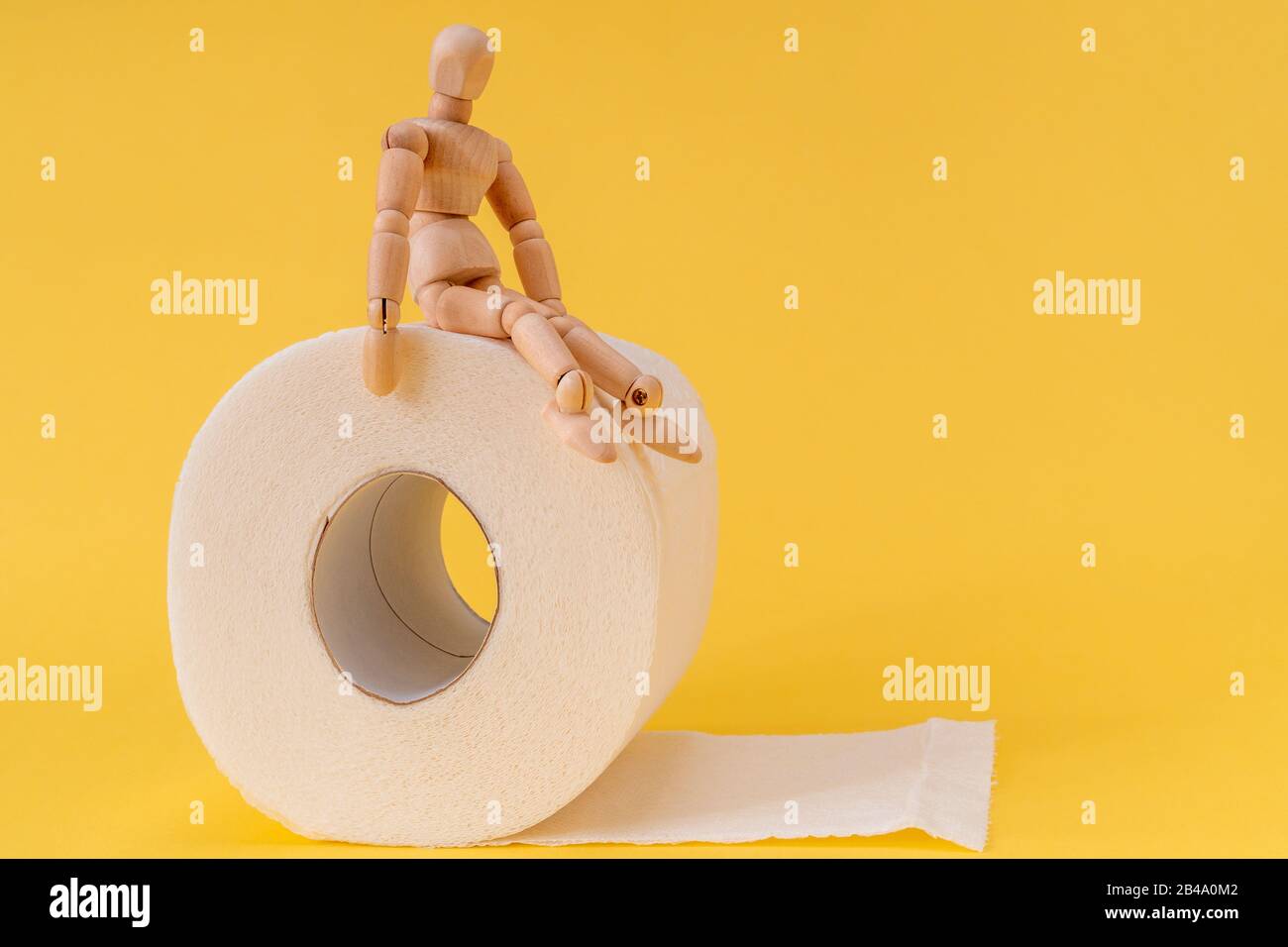 Wooden mannequin sit on a roll of toilet paper. Concept for ...
