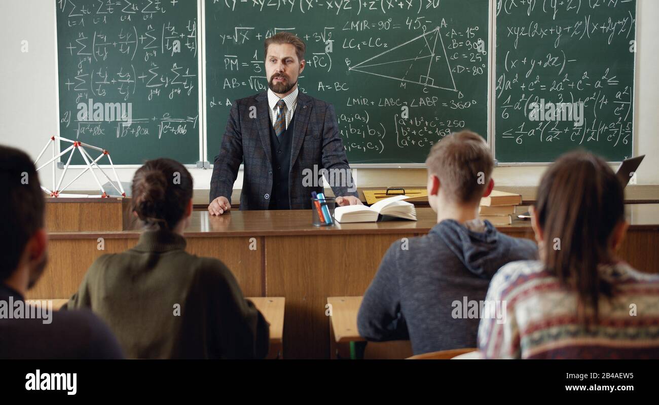 Teacher with students in classroom Stock Photo - Alamy