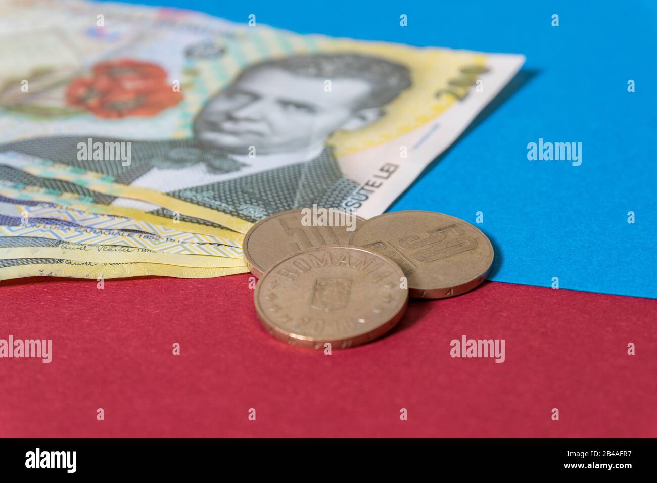 Romanian banknotes and coins on a blue and red background. Coloseup of ...