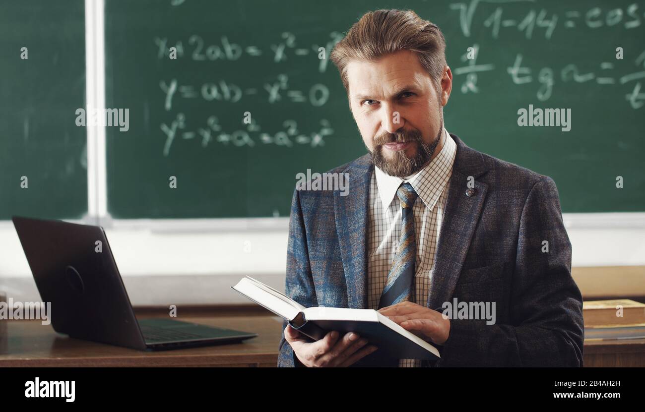 Math teacher holding open book Stock Photo - Alamy