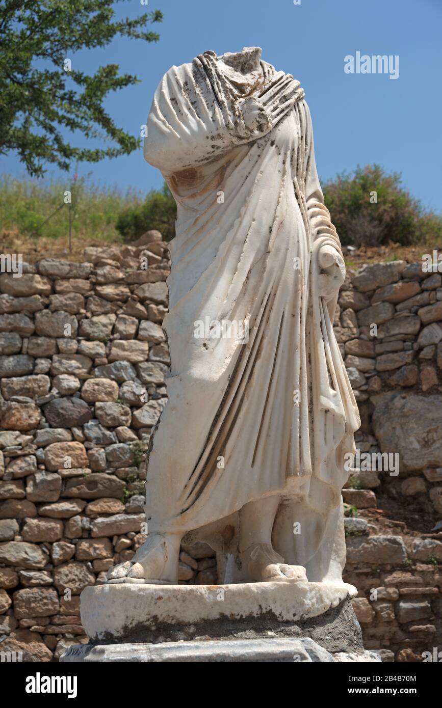 Old marble sculpture without head against blue sky background. Place ...