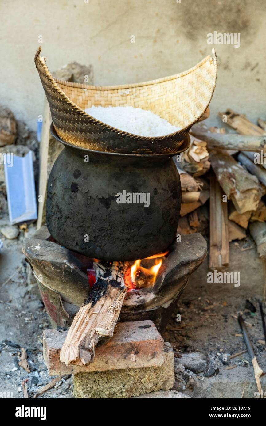 Laos, Oudomxay province, cooking of the rice in the kitchen of a ...