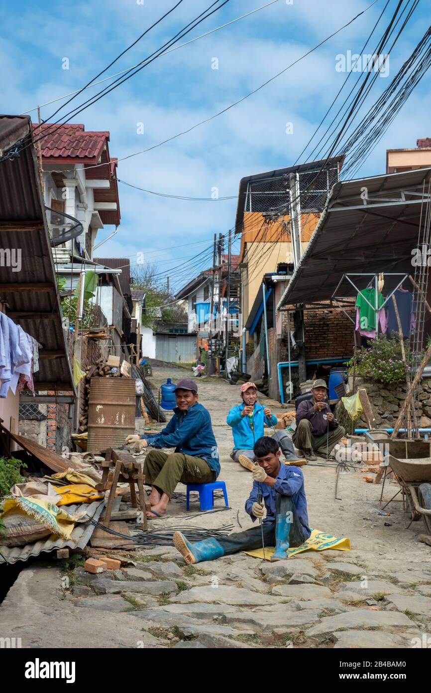 Laos, Phongsaly province, Phongsaly town, men working in a street of ...