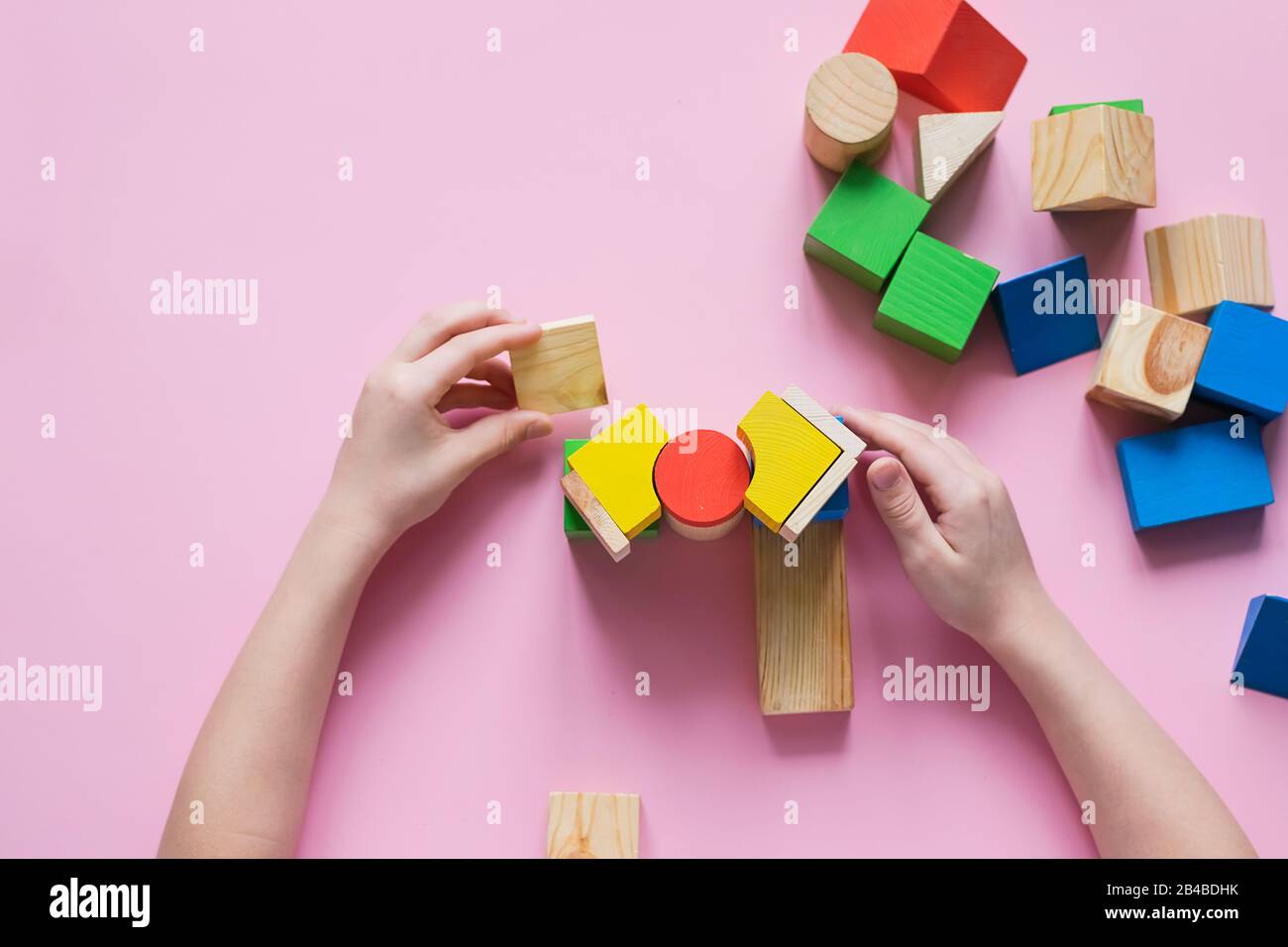 The child collects the designer builds a house of wooden cubes. Toys ...