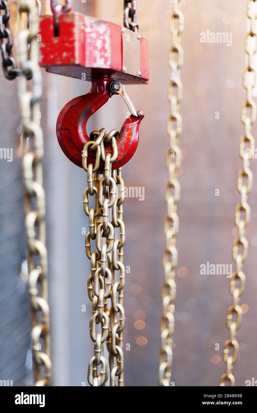 metallic chain handle with red hook in technical room. Crane cargo hook ...