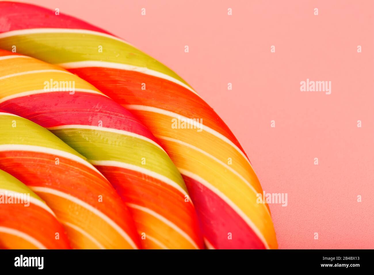 Lollipop multicolored close-up as background texture on pieces on pink ...