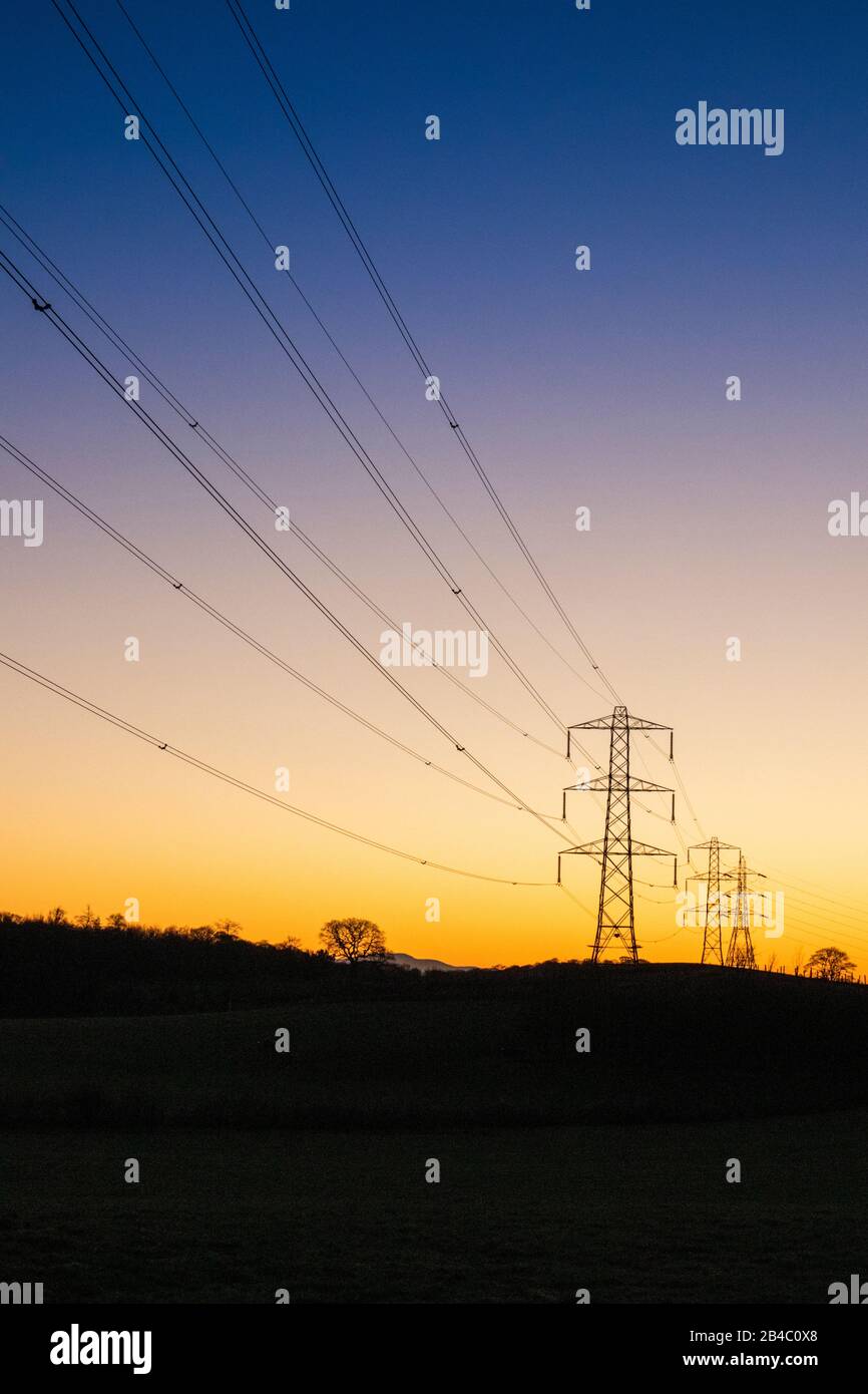 A winter sunset behind electricity power lines and pylons at Milton ...