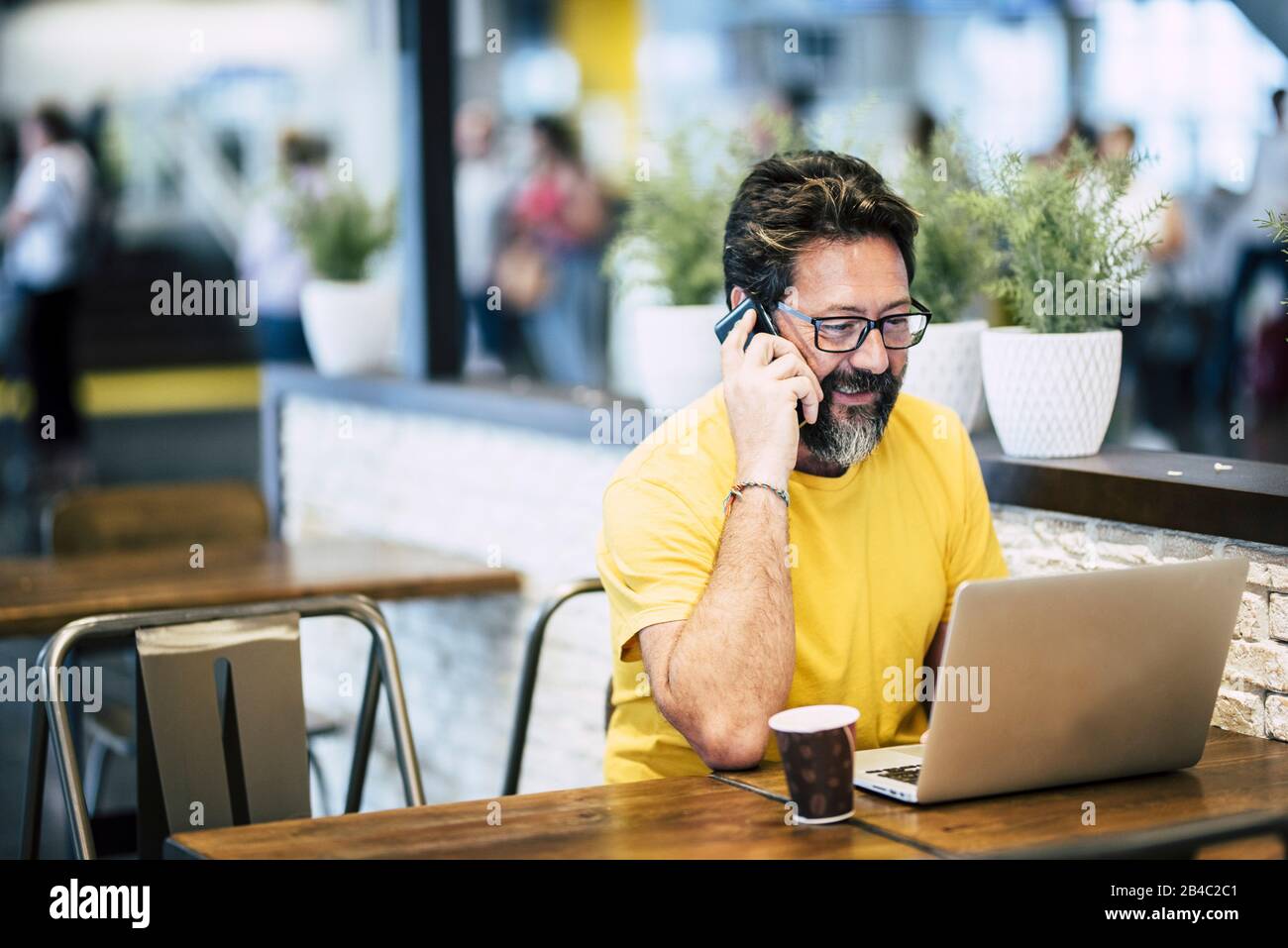 alone man at wood table working in her workplace with his laptop while ...