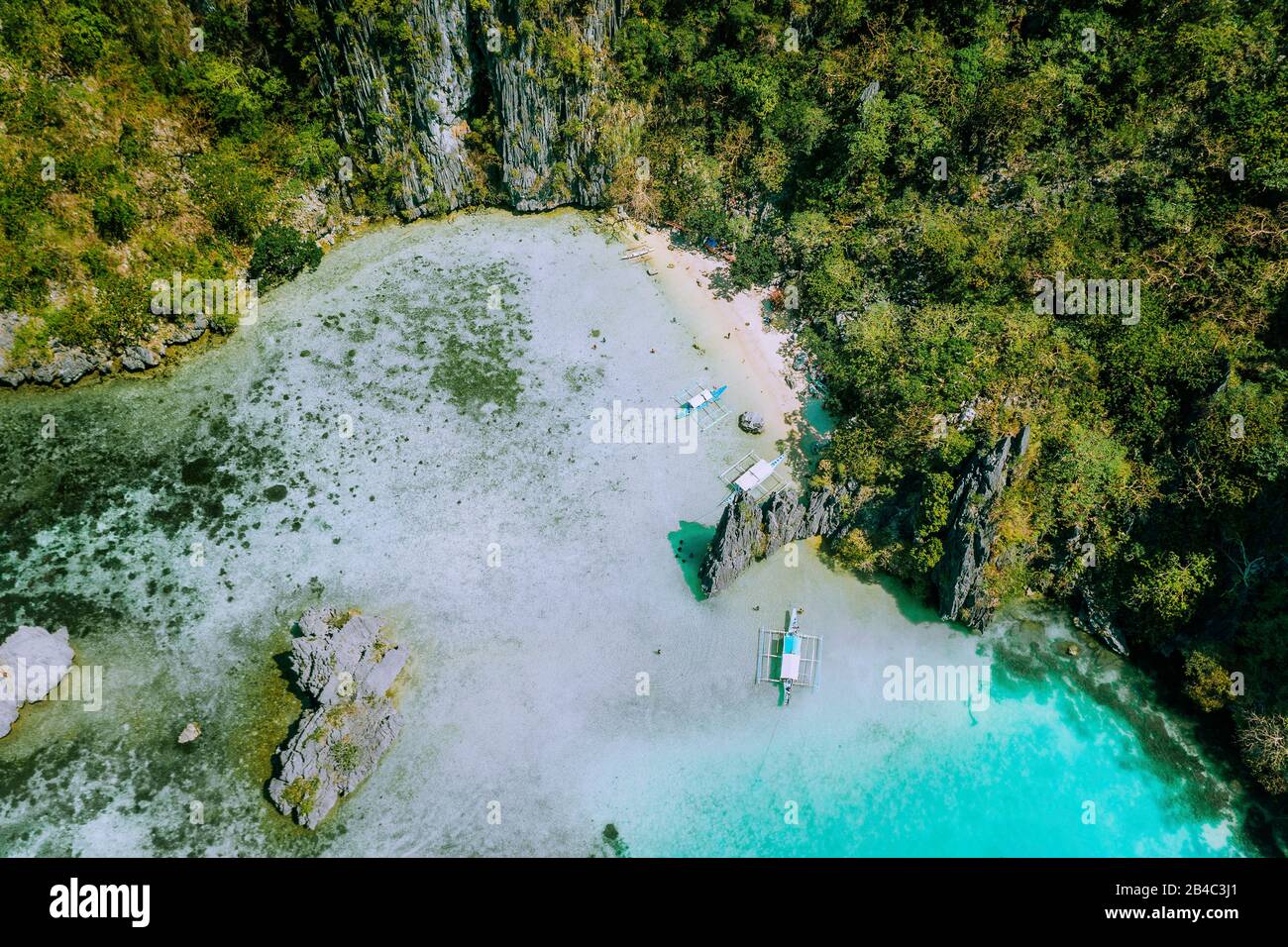 Aerial drone view of filippino tourist banca boats in shallow blue ...