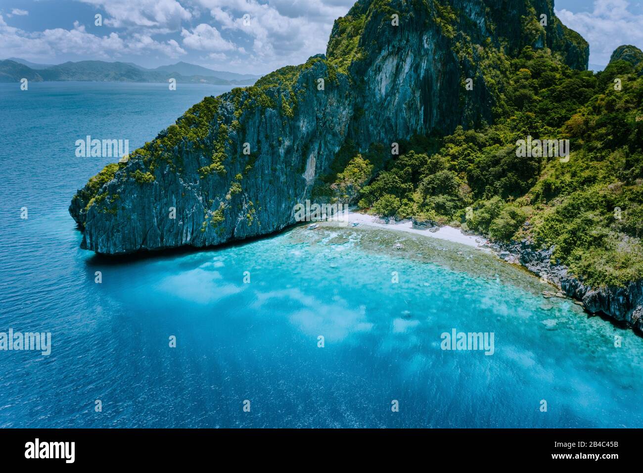 Aerial drone view of tropical Entalula Island. Huge steep rocks cliffs ...