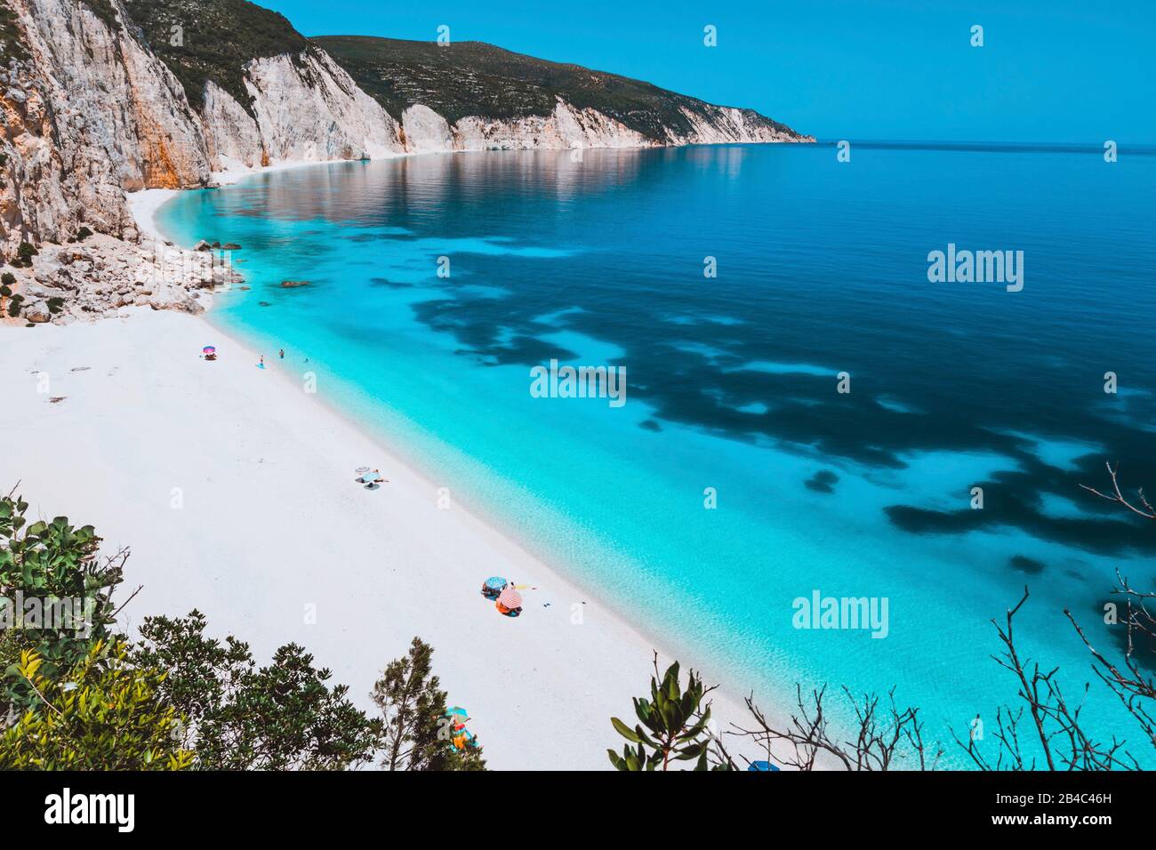 Sunny idyllic Fteri beach lagoon with limestone rocky coastline ...